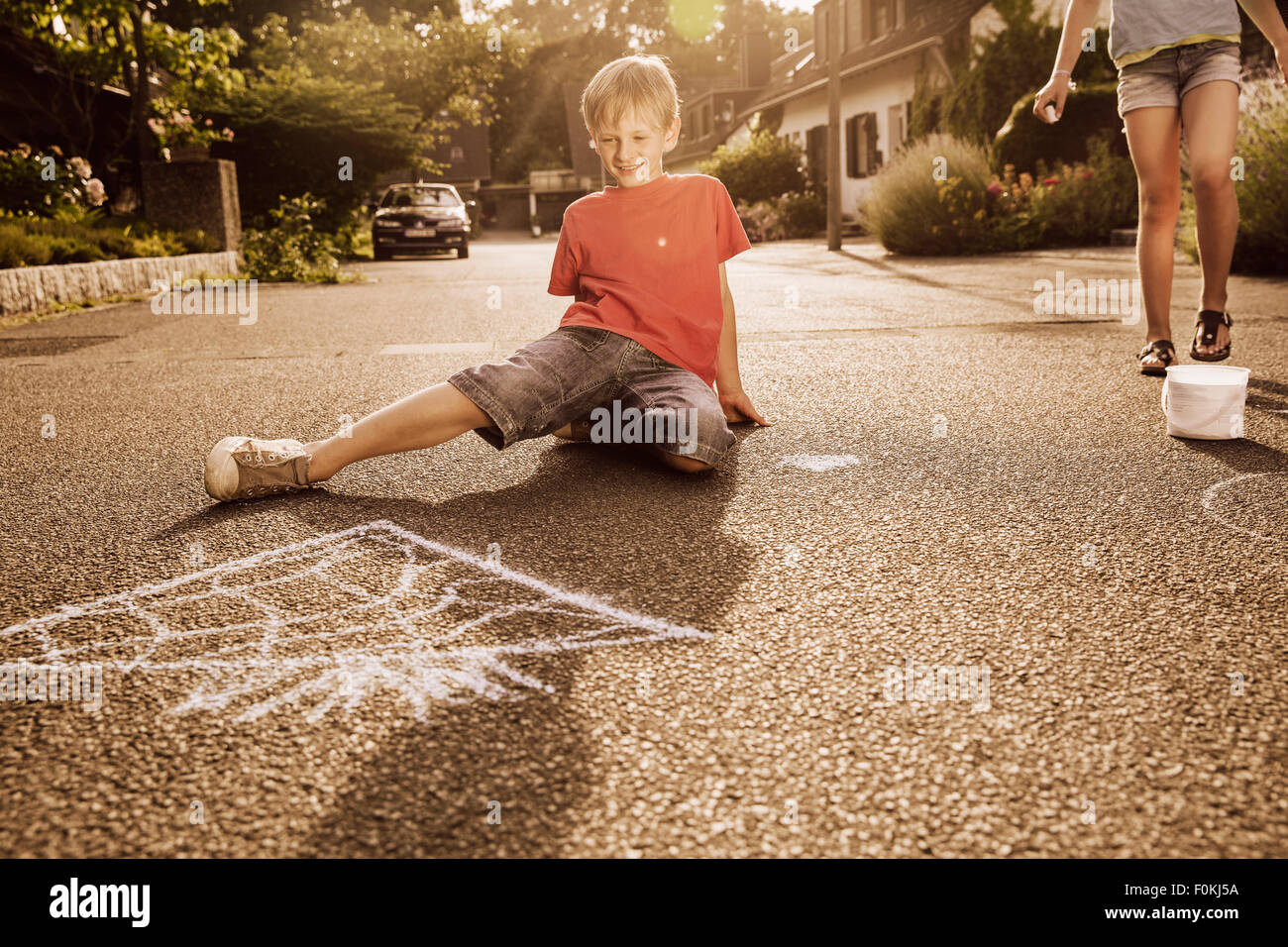 Children using sidewalk chalk in their neighborhood Stock Photo - Alamy