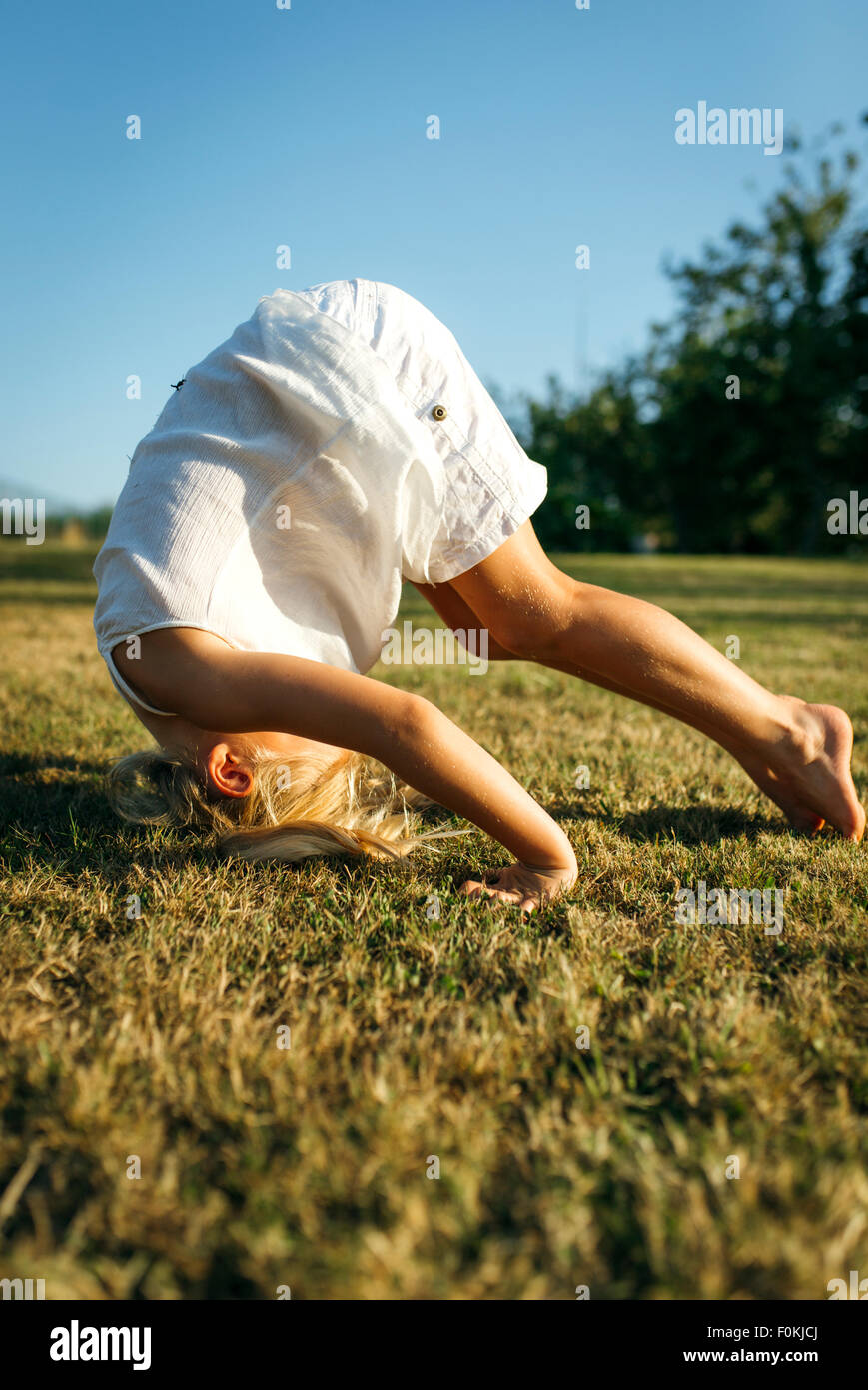 Little girl doing a somersault on a meadow Stock Photo - Alamy