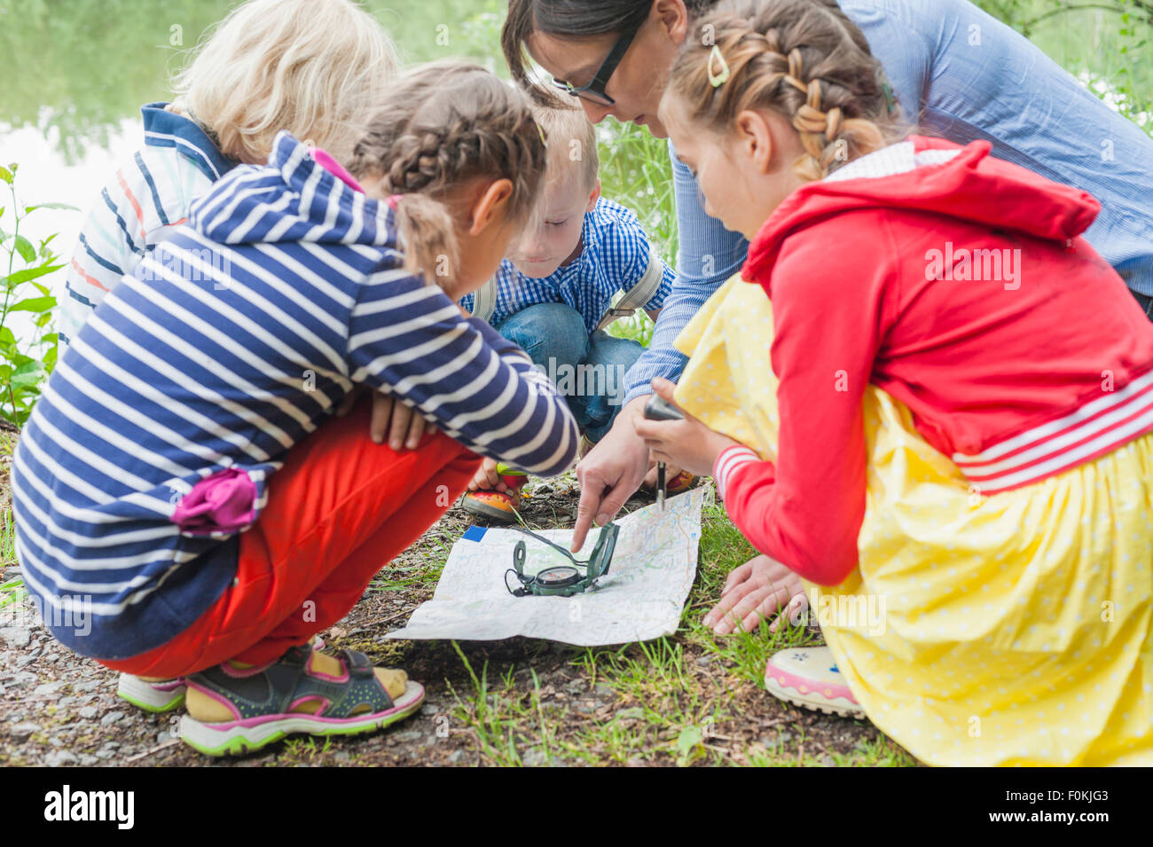 Germany, Children learning how to use compass and map Stock Photo - Alamy