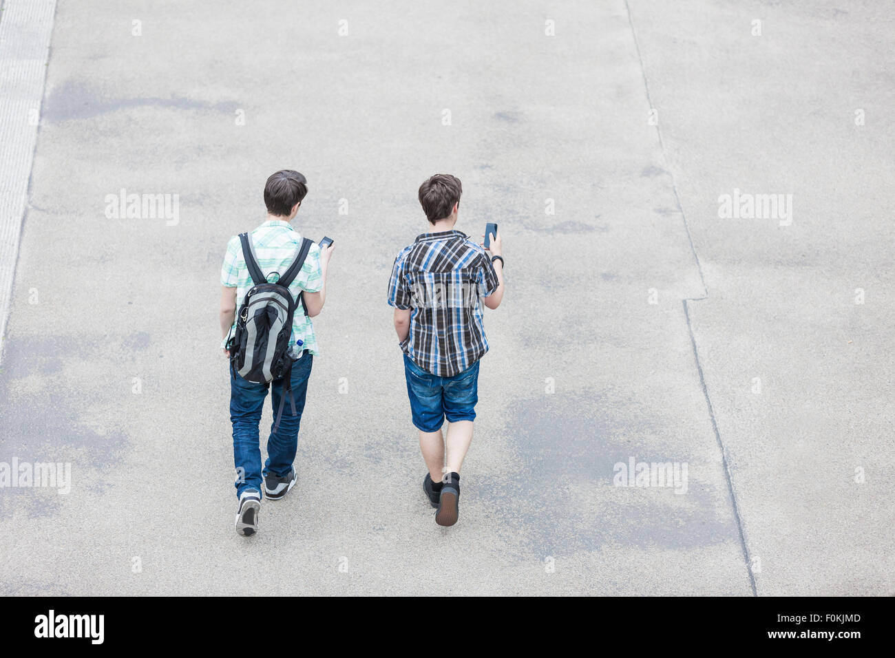 Back view of two teenage boys with smartphones Stock Photo - Alamy