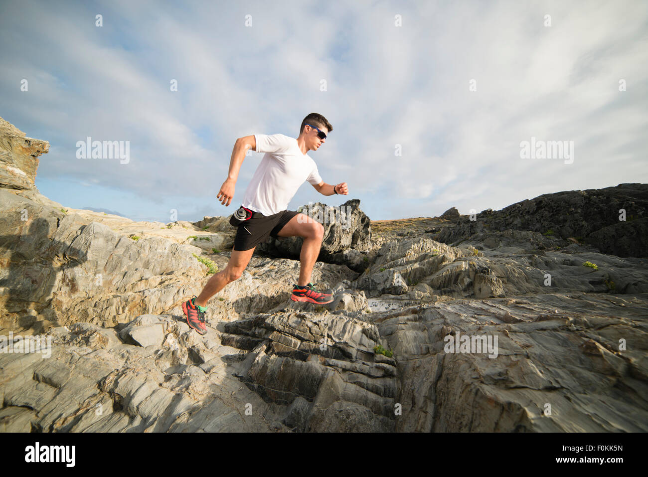 Young man running on the rocks hi-res stock photography and images - Alamy