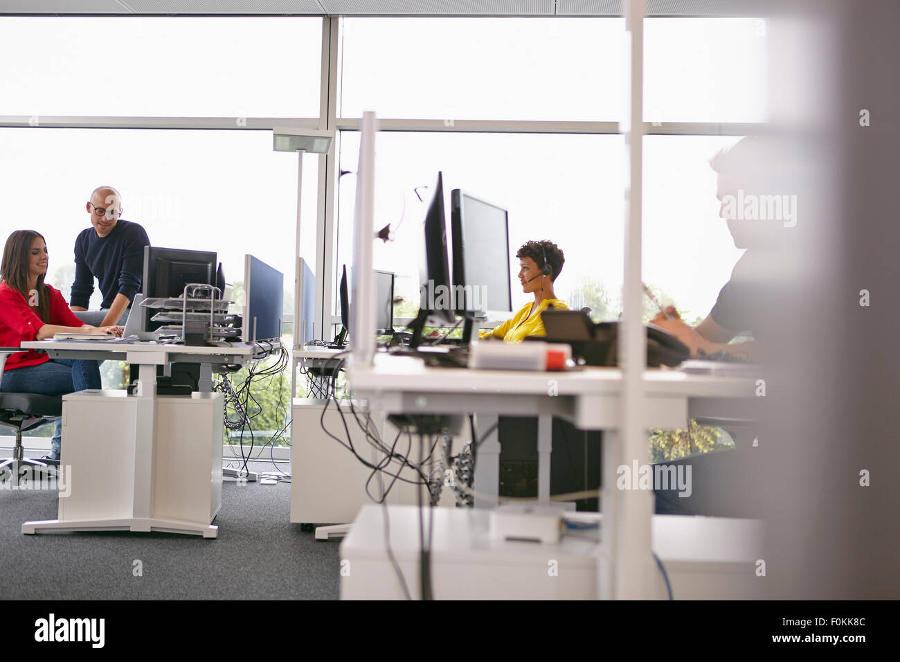 Colleagues working in open-plan office Stock Photo - Alamy