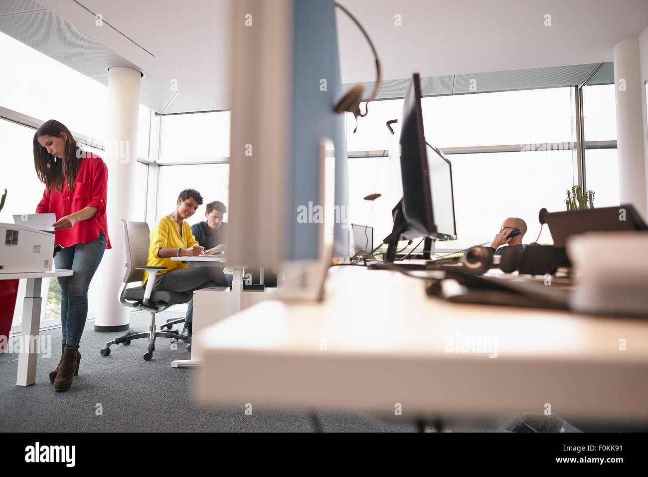 Colleagues working in open-plan office Stock Photo - Alamy