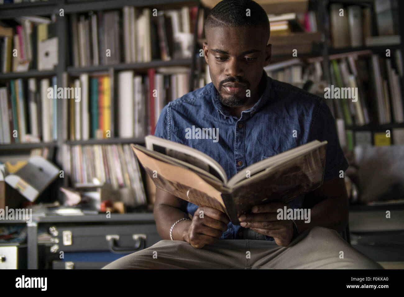 Young man reading book in his studio Stock Photo - Alamy