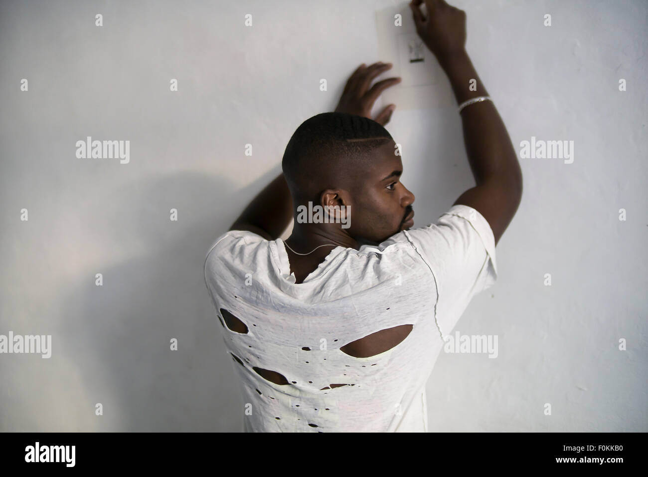 Young man fixing drawing on the wall in his studio Stock Photo - Alamy