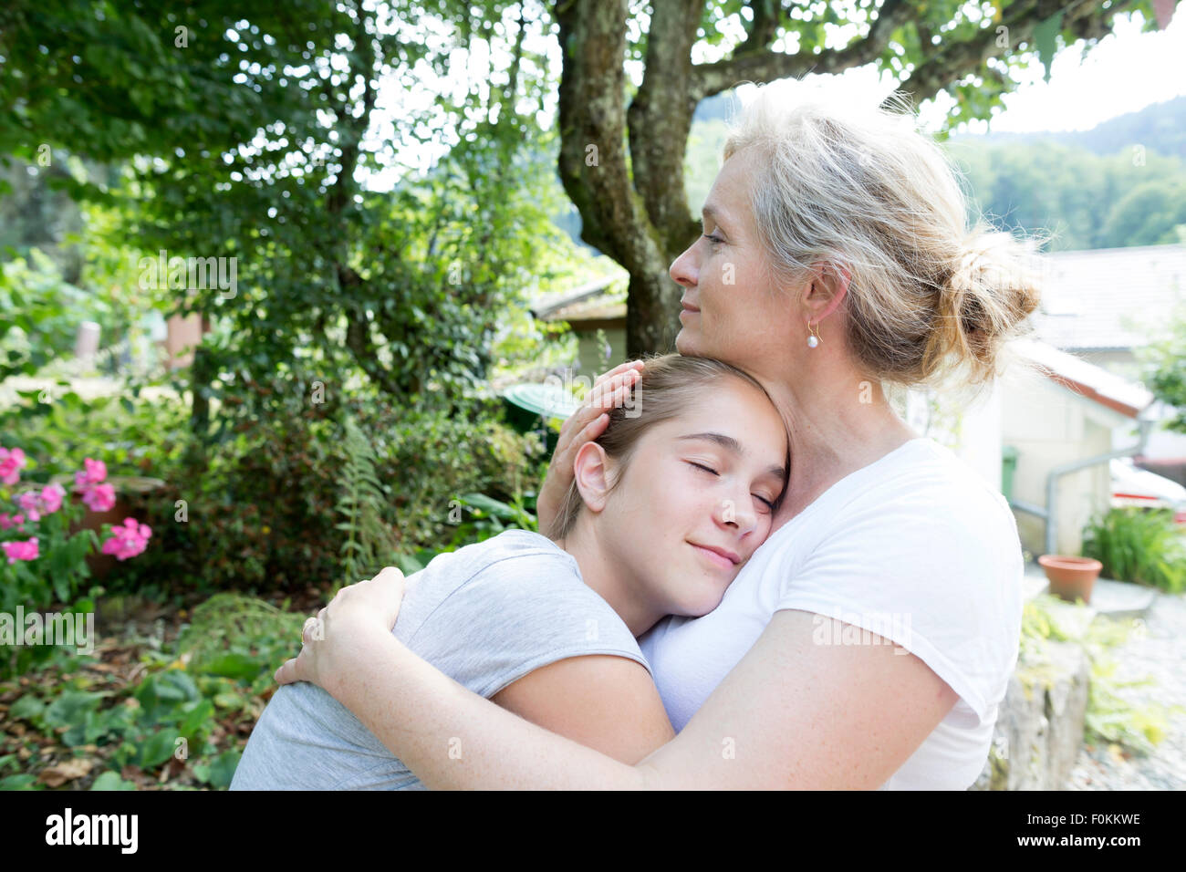 Mother and daughter hugging Stock Photo - Alamy