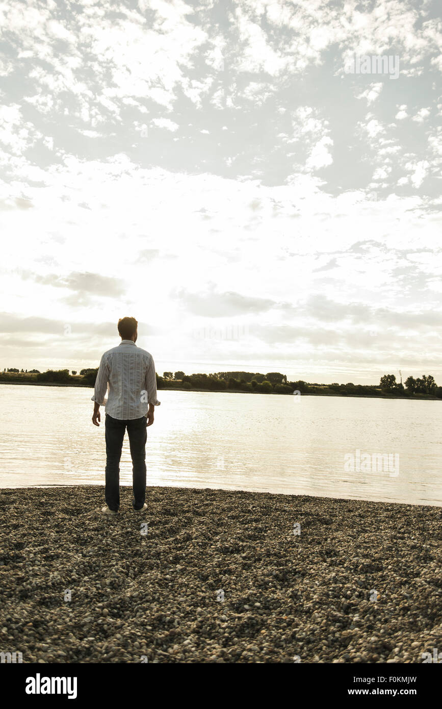 Relaxed man standing riverside looking view hi-res stock photography ...