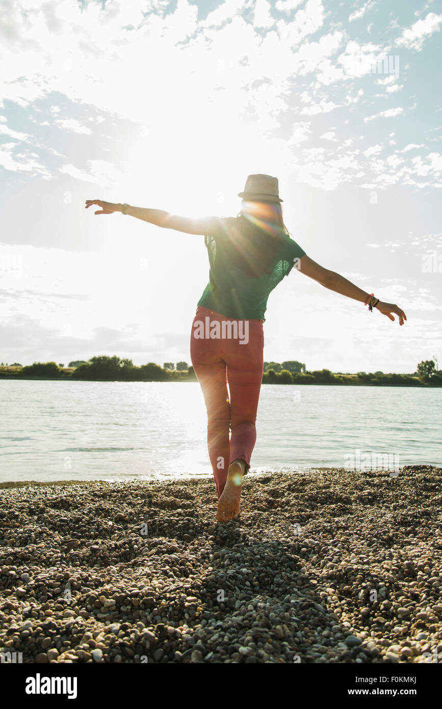 Young woman balancing by the riverside Stock Photo - Alamy