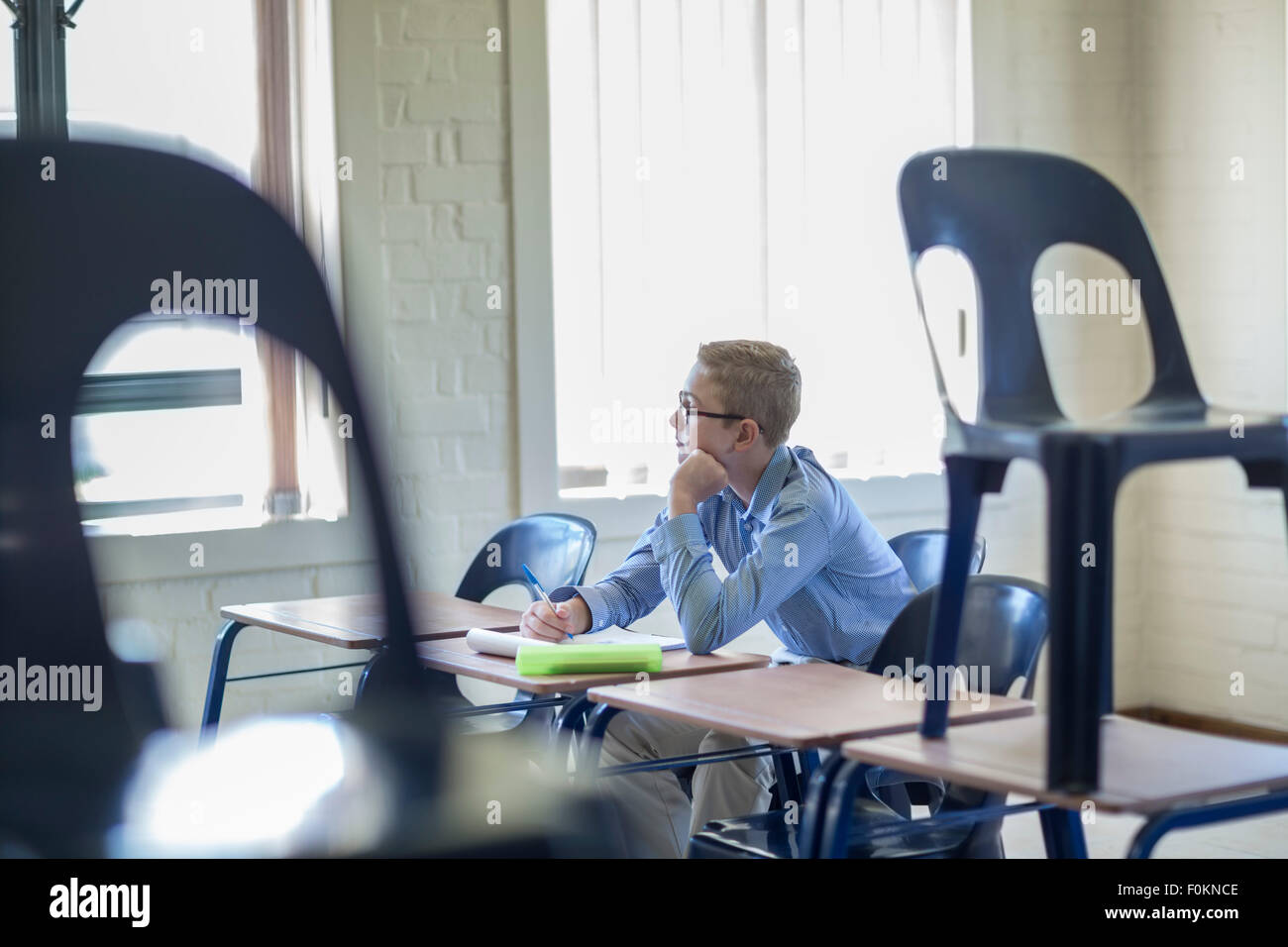 Schoolboy alone in classroom Stock Photo - Alamy