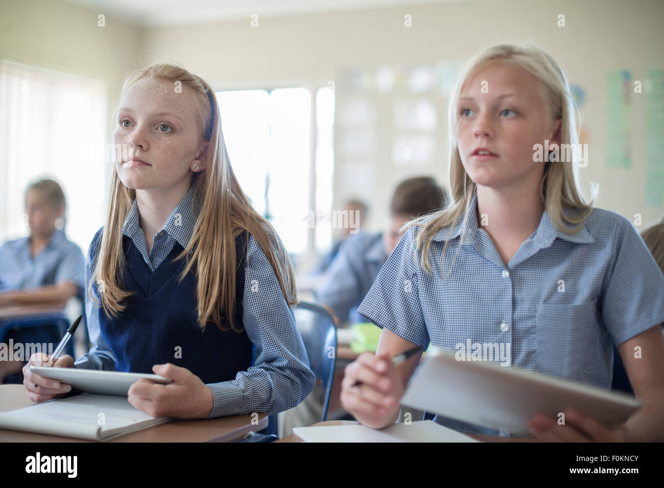 Two schoolgirls in classroom with digital tablets Stock Photo - Alamy