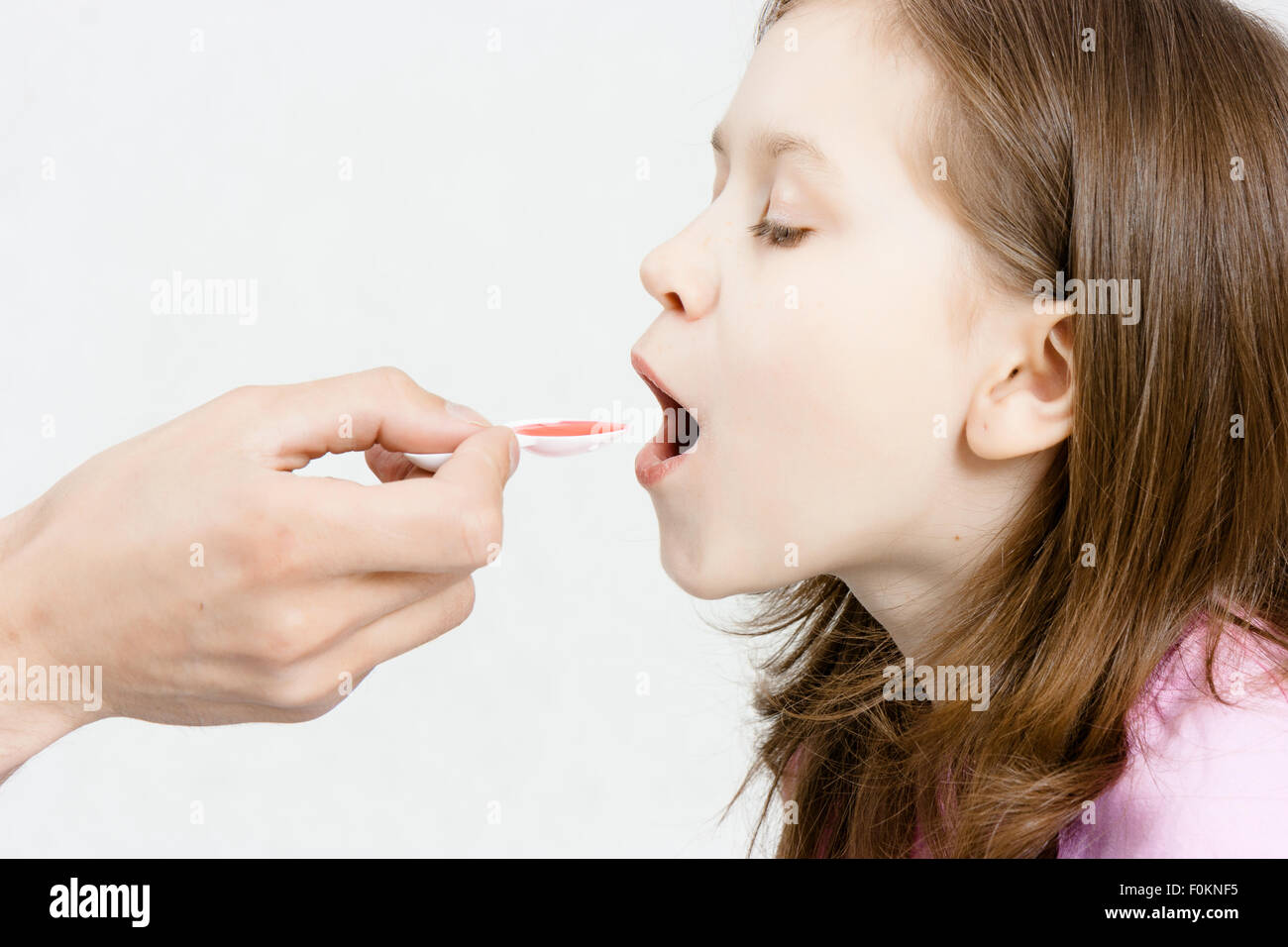 Treatment of the child. Girl is drinking red medicinal syrup Stock ...