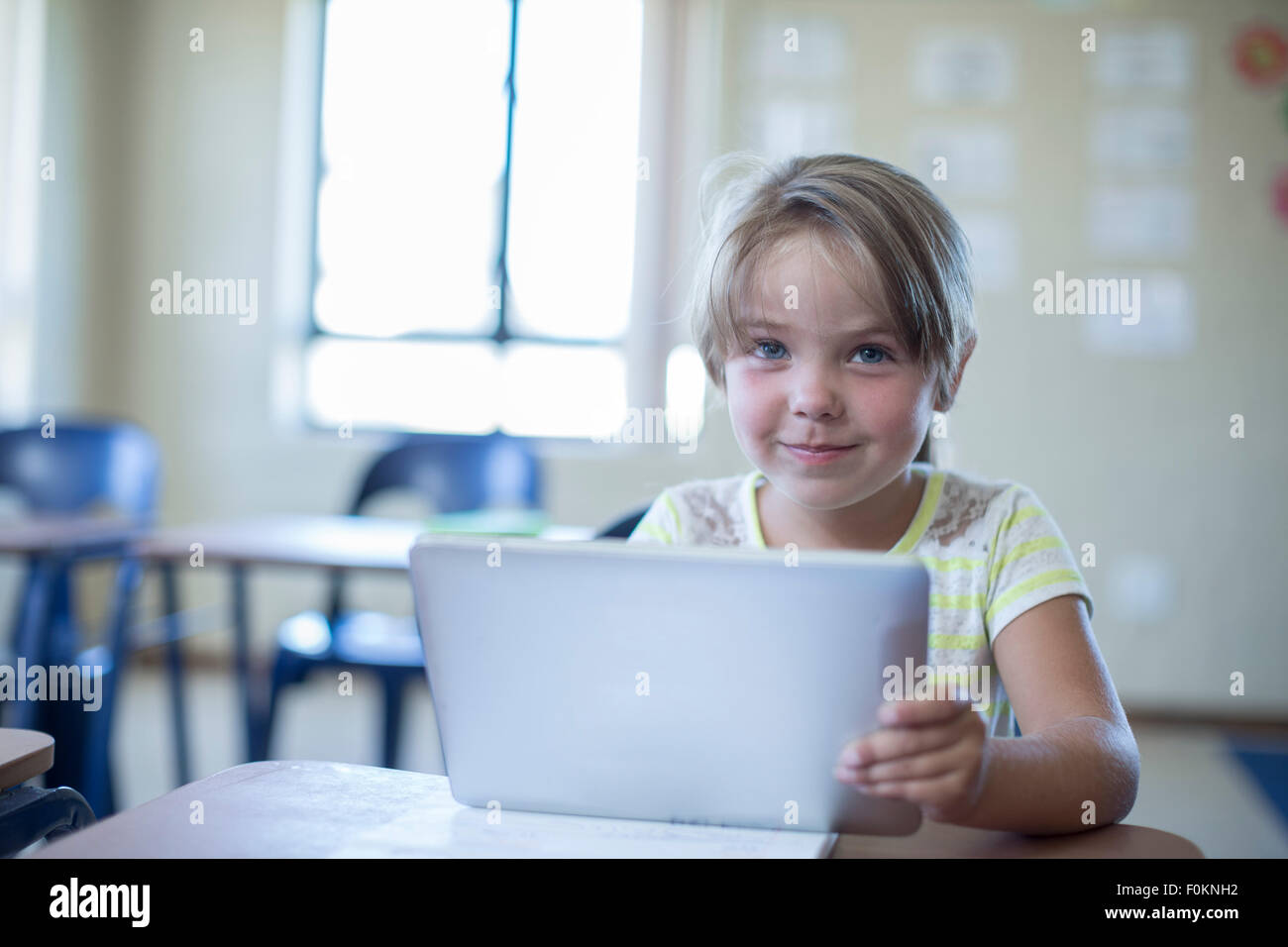 Portrait of smiling primary schoolgirl with digital tablet Stock Photo ...
