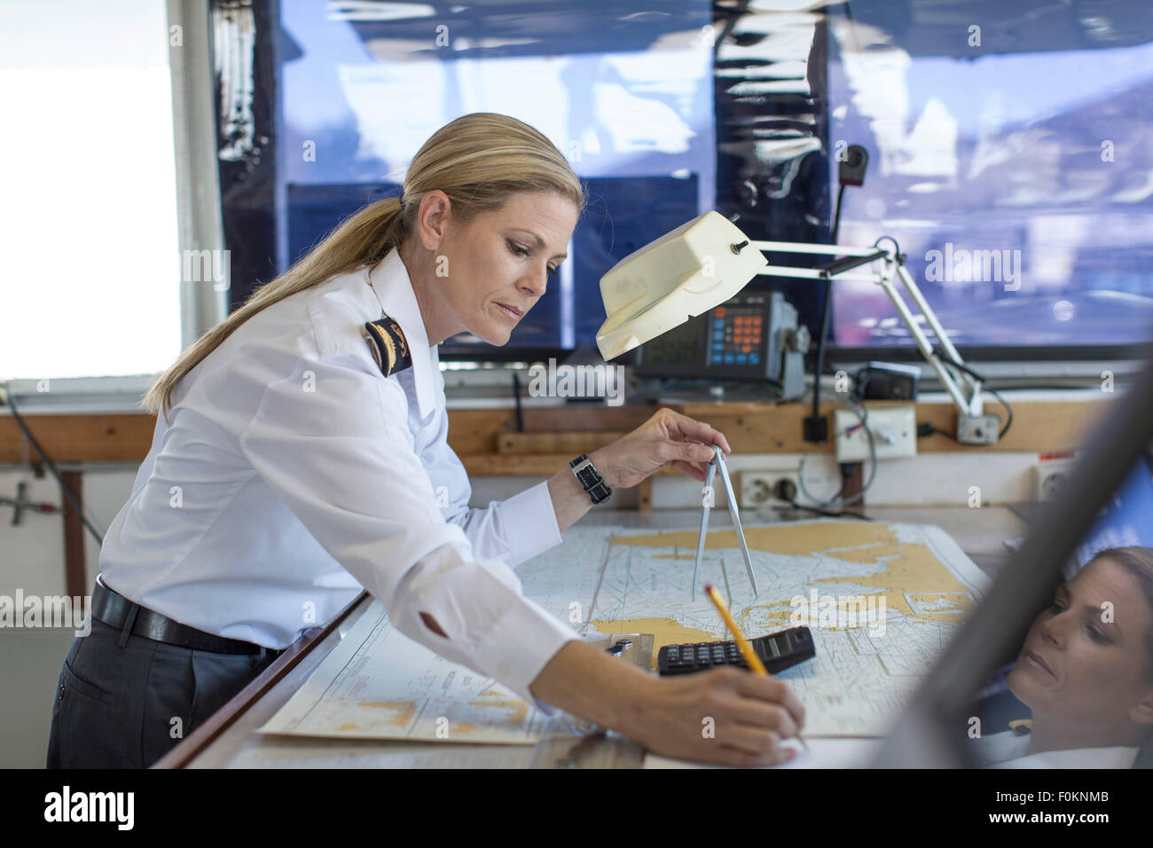 Female deck officer working on a nautical map Stock Photo - Alamy