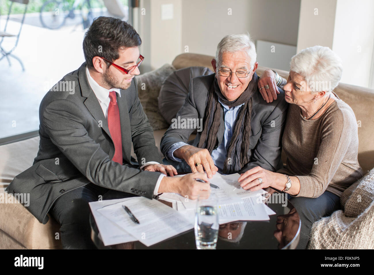 Senior couple at home having a meeting with salesman Stock Photo - Alamy