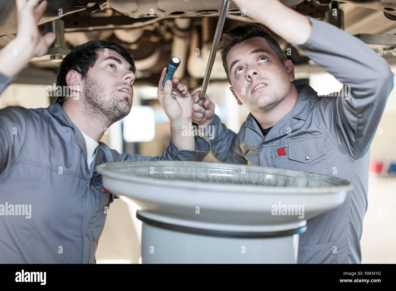 Two car mechanics at work in repair garage Stock Photo - Alamy