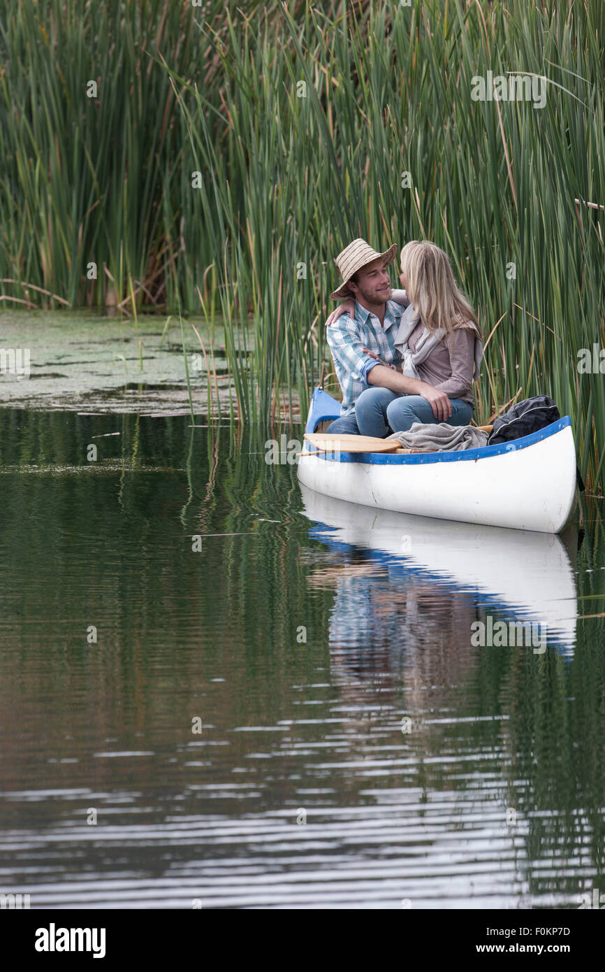 Young couple sitting face to face in a canoe on a lake Stock Photo - Alamy