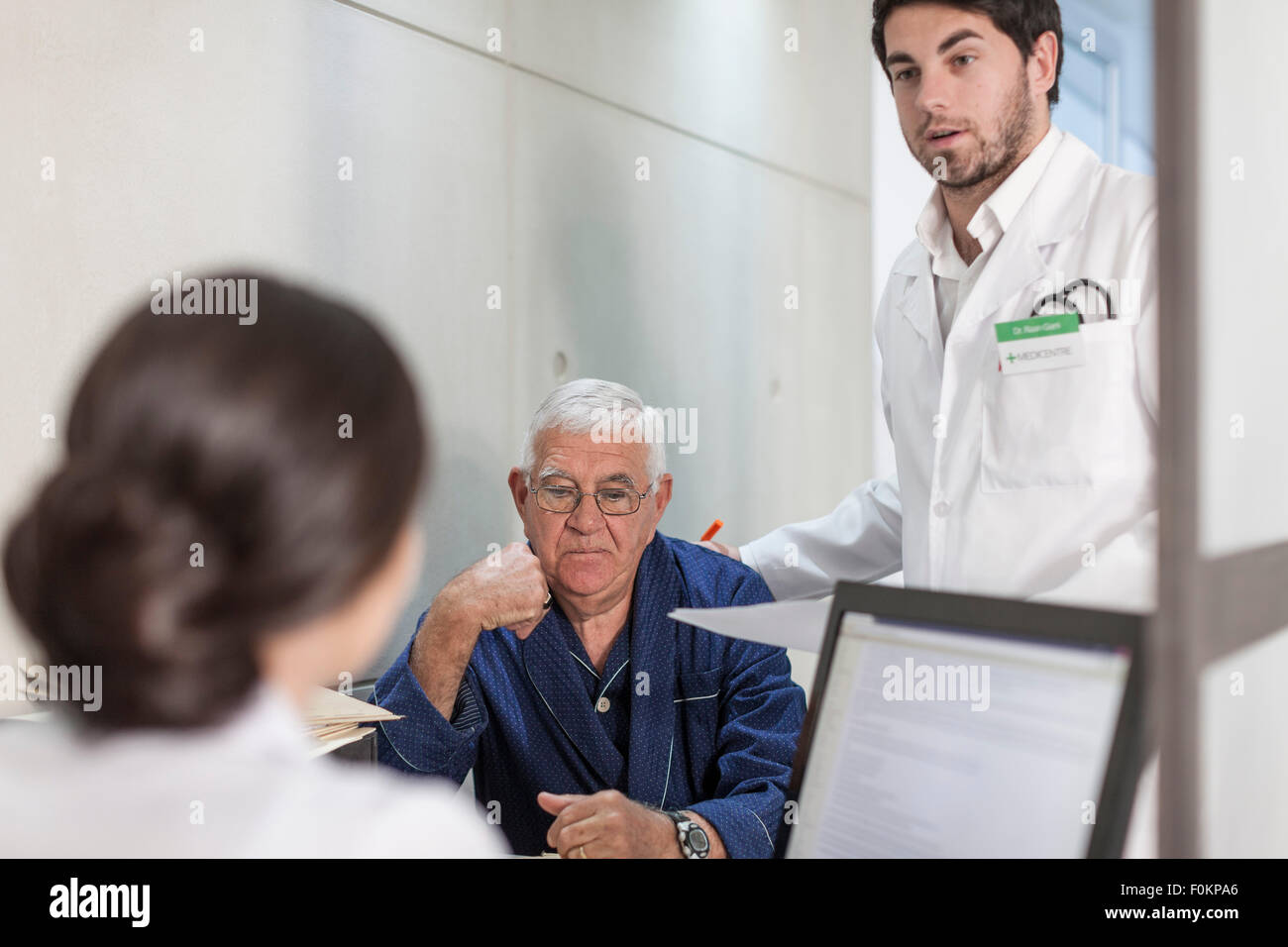 Nurse and doctor helping patient at clinic reception Stock Photo - Alamy