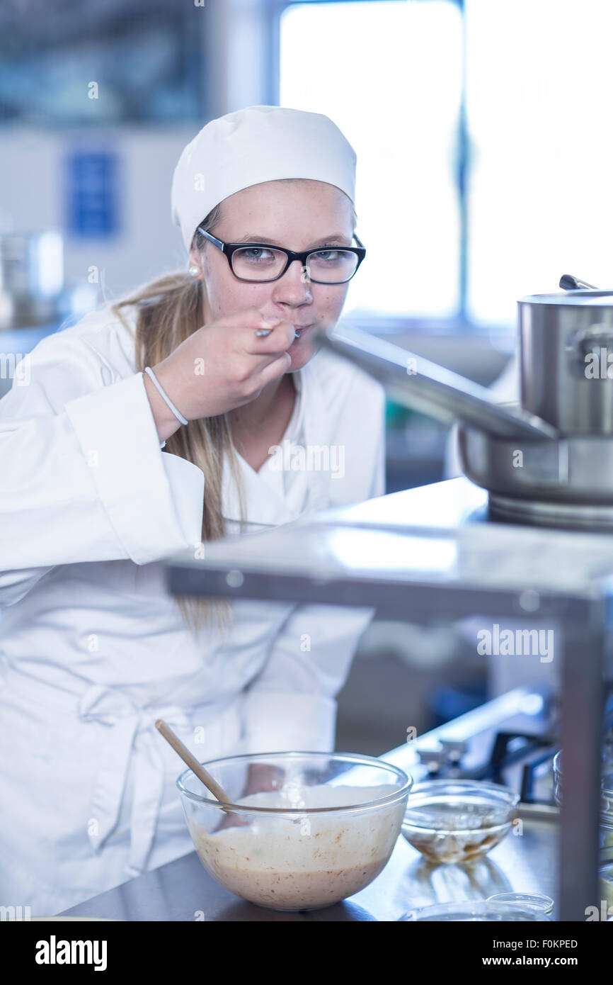 Teenage girl in kitchen cooking class tasting Stock Photo - Alamy