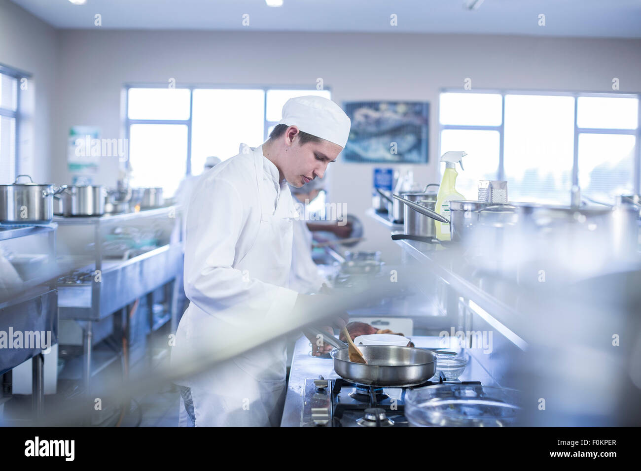 Teenager cooking in canteen kitchen Stock Photo - Alamy