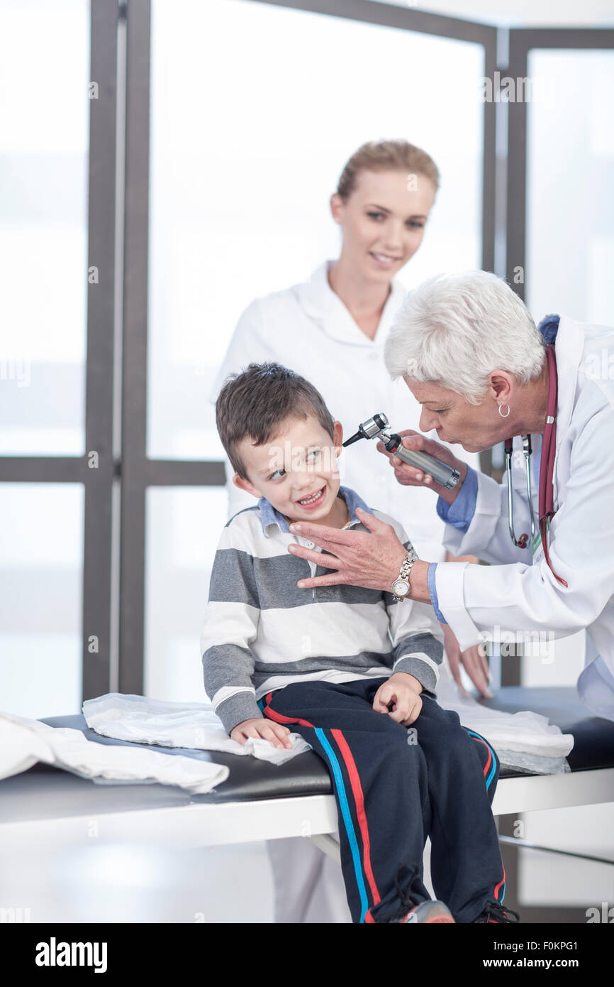 Doctor examining ears of little boy Stock Photo - Alamy