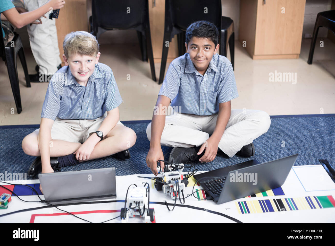 Two smiling schoolboys with laptops in robotics class Stock Photo - Alamy