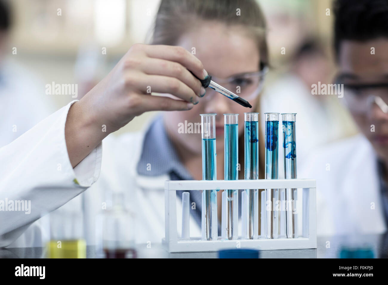Students in chemistry class pipetting liquid into test tube Stock Photo ...