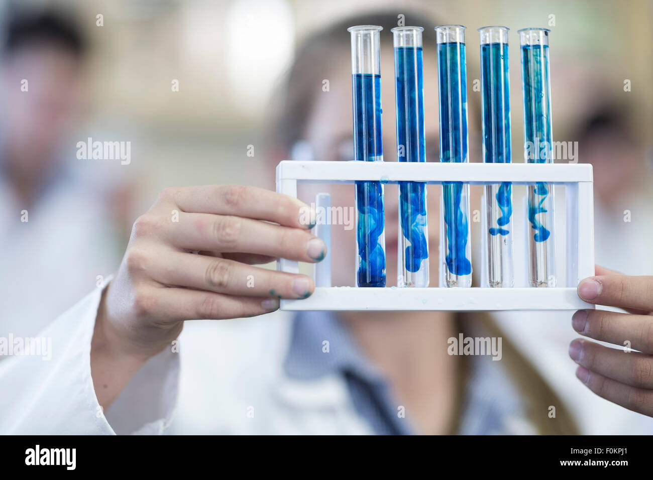 Girl in chemistry class holding test tube rack Stock Photo - Alamy