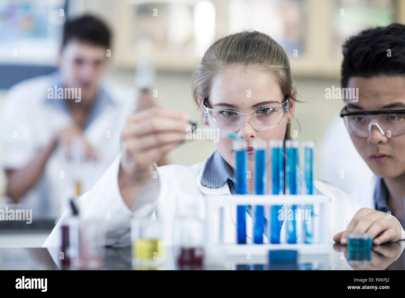 Students in chemistry class pipetting liquid into test tube Stock Photo ...