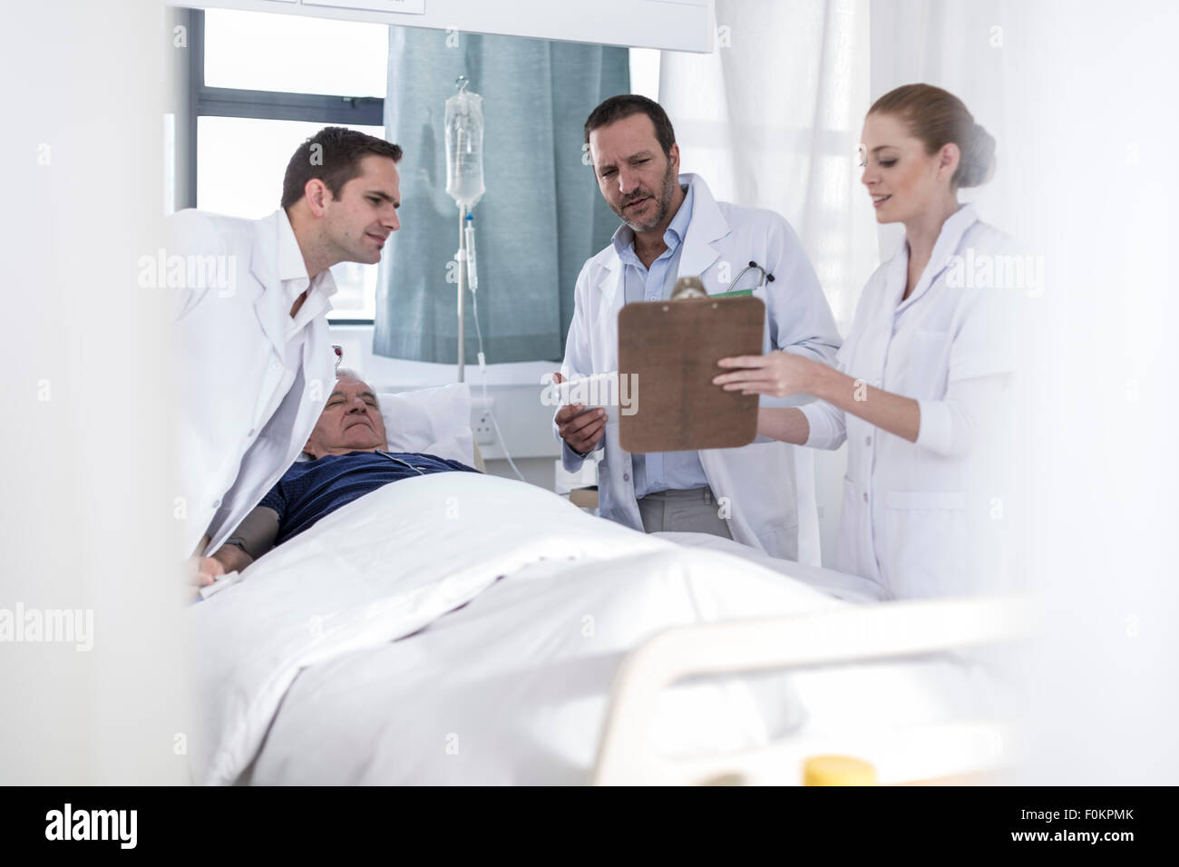 Two doctors, nurse and patient in a hospital room Stock Photo - Alamy