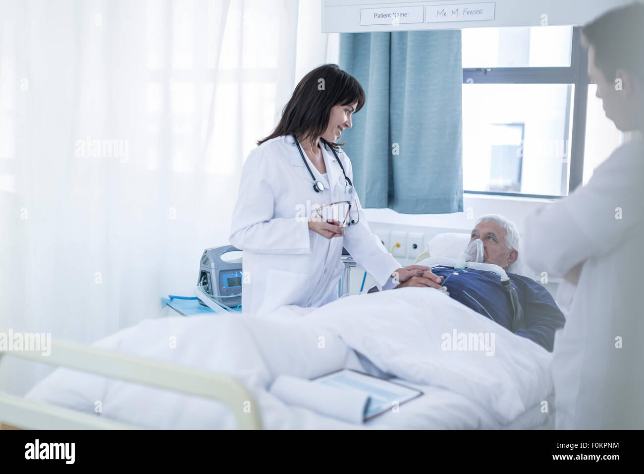 Two doctors and a patient in a hospital room Stock Photo - Alamy