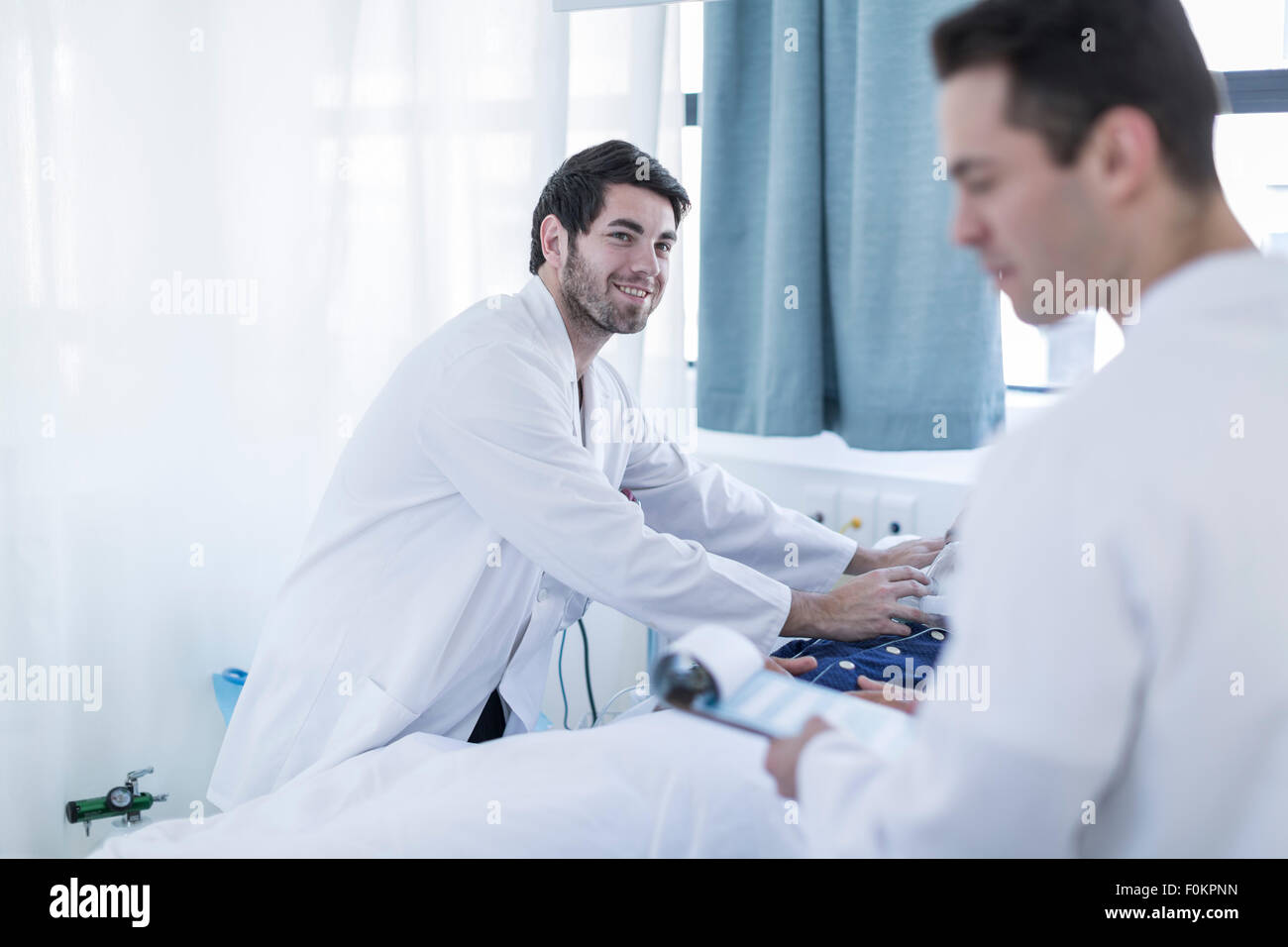 Two doctors examining a patient in a hospital room Stock Photo - Alamy