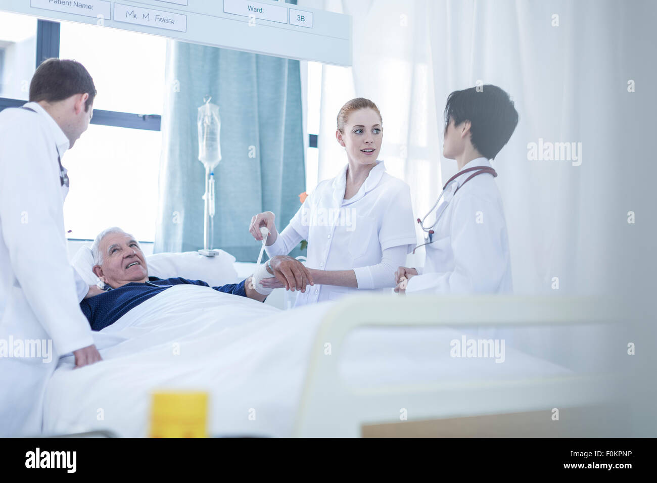 Two doctors, nurse and a patient in a hospital room Stock Photo - Alamy