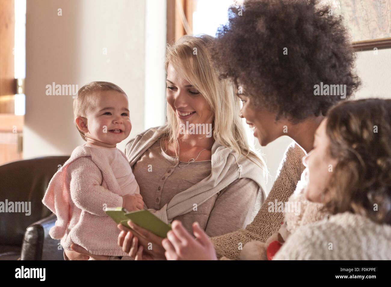 Four happy young women with baby Stock Photo - Alamy