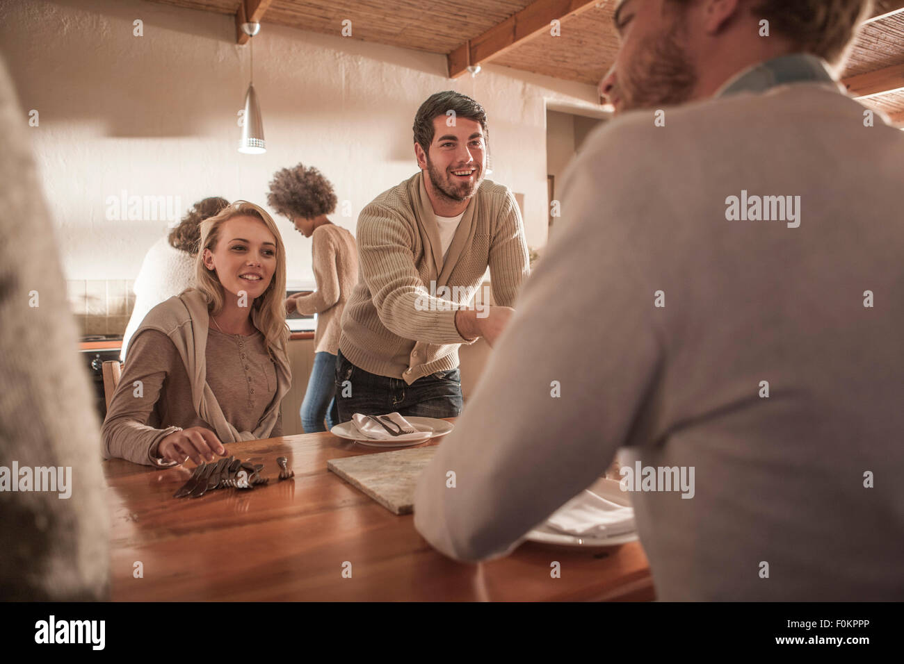 Friends setting a table together Stock Photo - Alamy