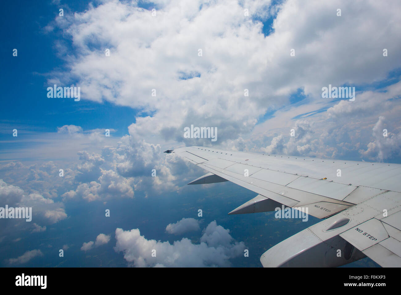 Wing of an airplane cruising above the clouds Stock Photo - Alamy