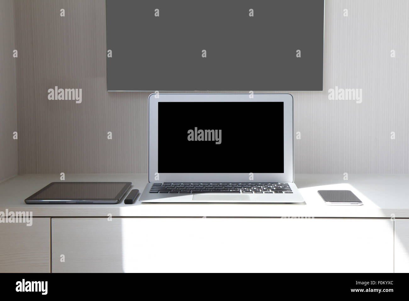 blank screen laptop computer and smart phone and digital tablet and stylus pen and poster is on ...