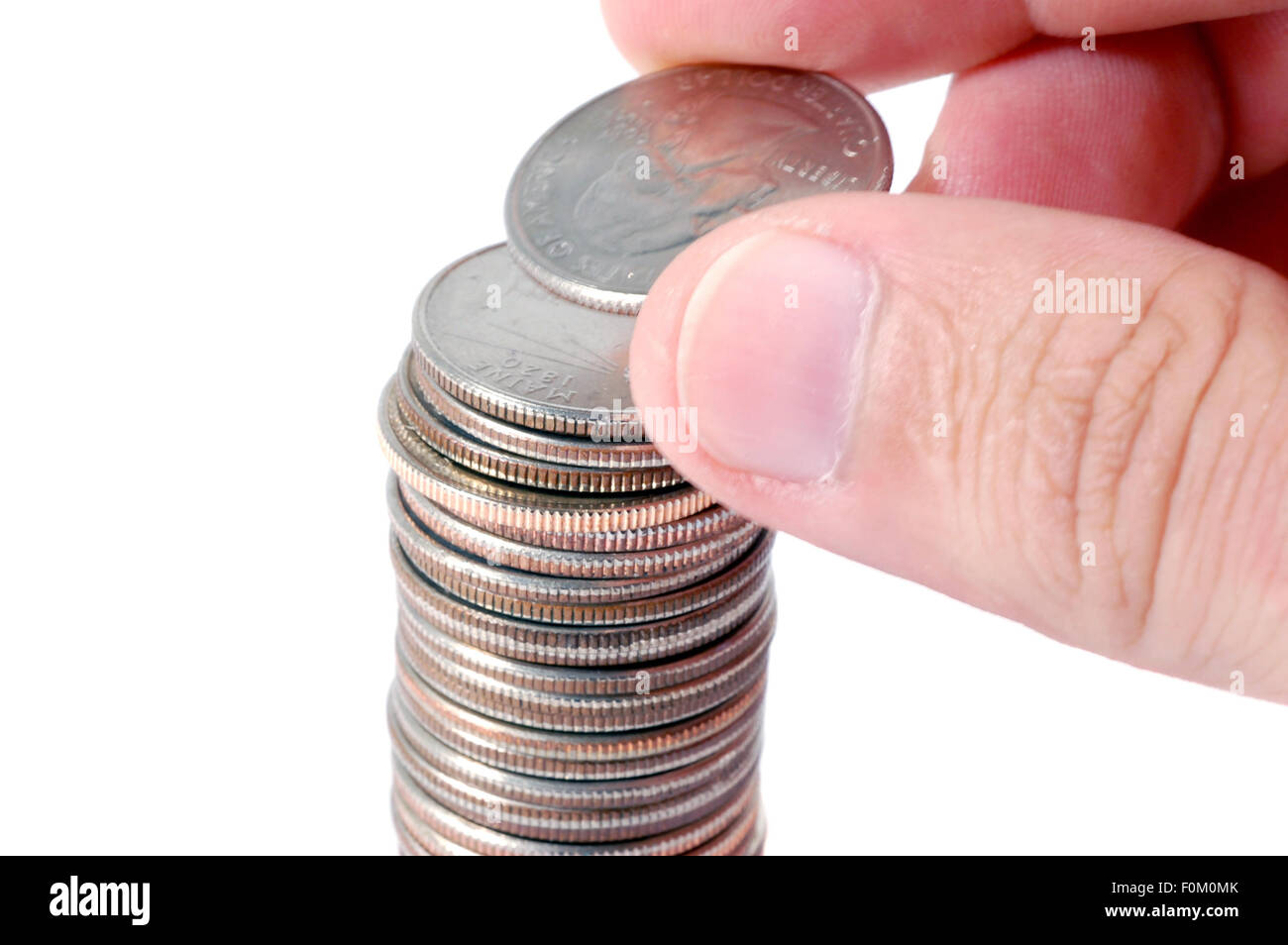 Hand building a tower of quarters isolated on a white background Stock ...