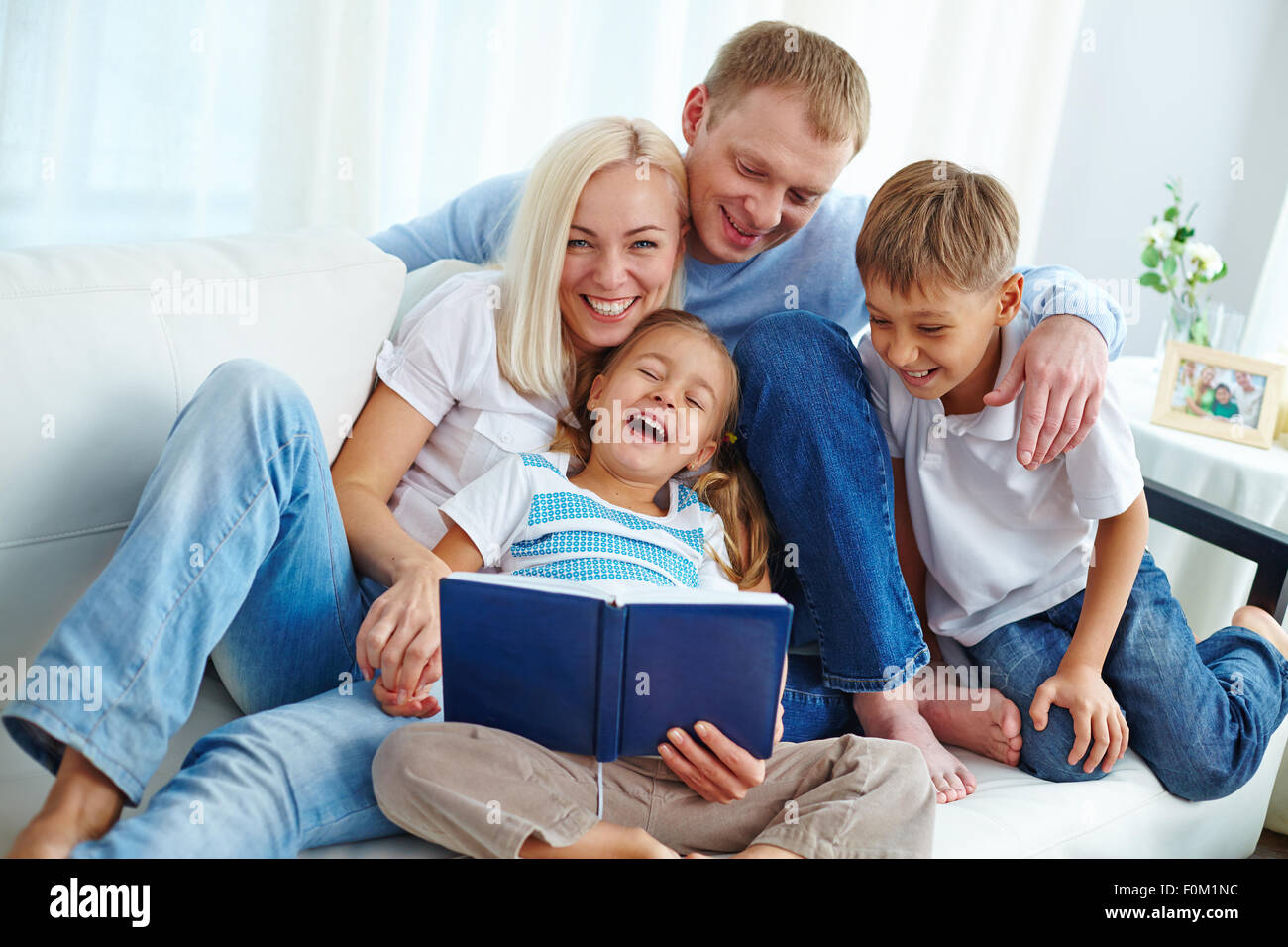Joyful family reading together Stock Photo - Alamy