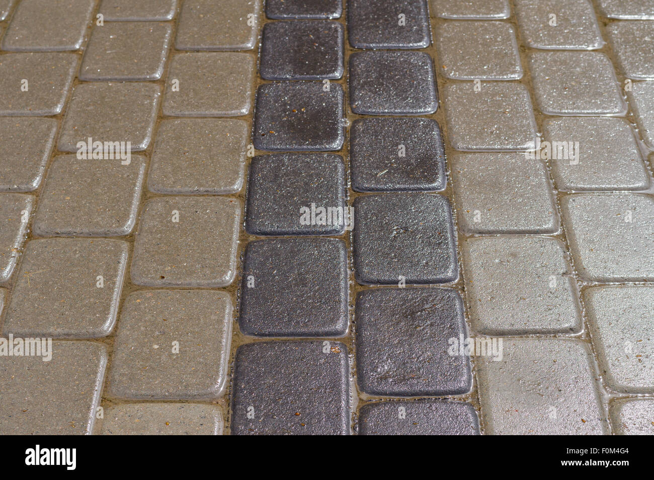 Wet decorative dark and light tiles, road detail Stock Photo - Alamy