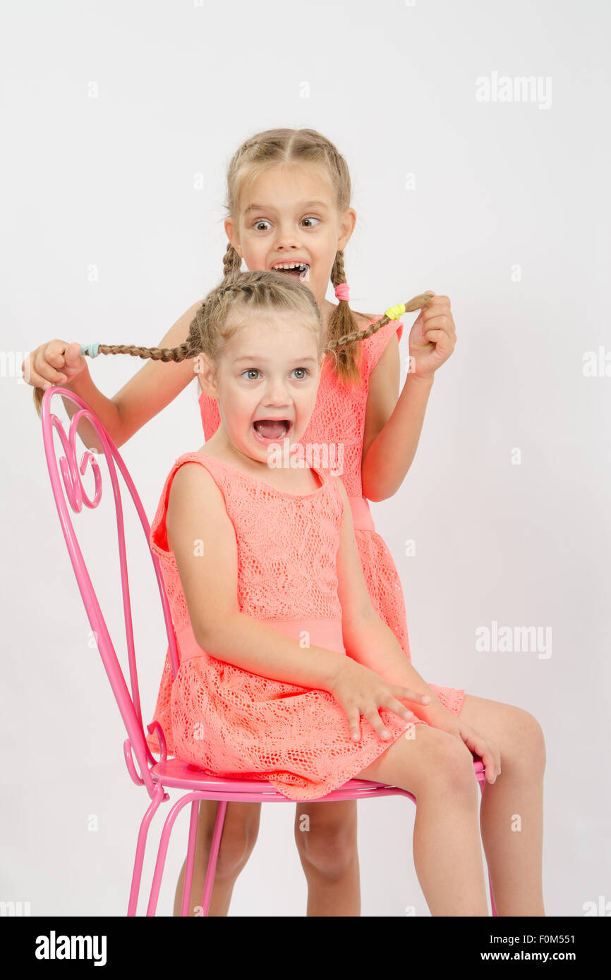 Two girls sisters in the same clothes having fun playing with each ...