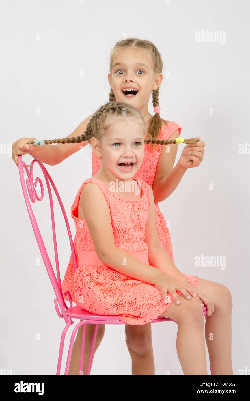 Two girls sisters in the same clothes having fun playing with each ...