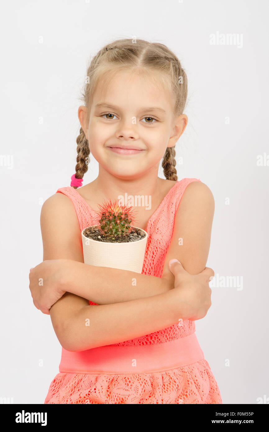 Six Year Old Girl Standing With A Cactus In A Pot Isolated On A Light