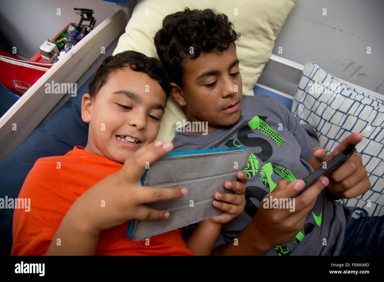 Two brothers playing on their games consoles indoors Stock Photo - Alamy