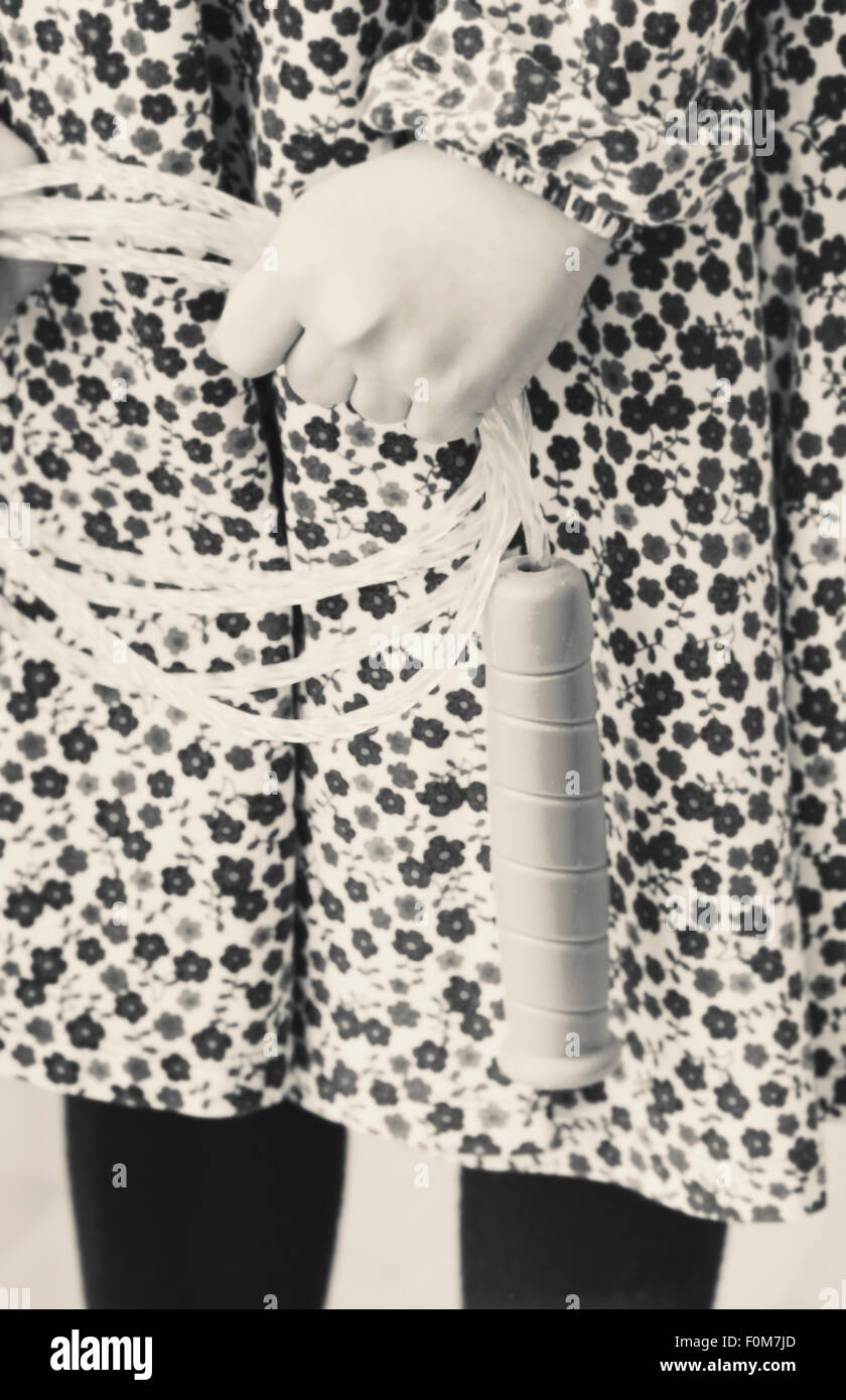 Portrait of little girl in dress with flowers. She is holding a jump ...