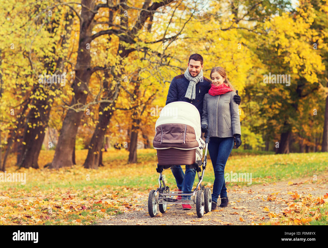 smiling couple with baby pram in autumn park Stock Photo - Alamy