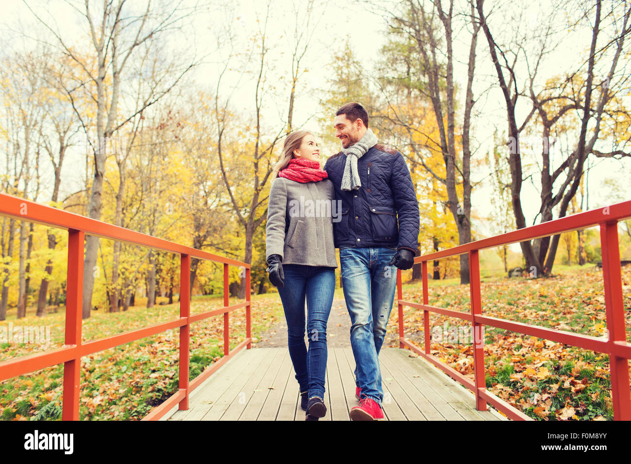 smiling couple hugging on bridge in autumn park Stock Photo - Alamy