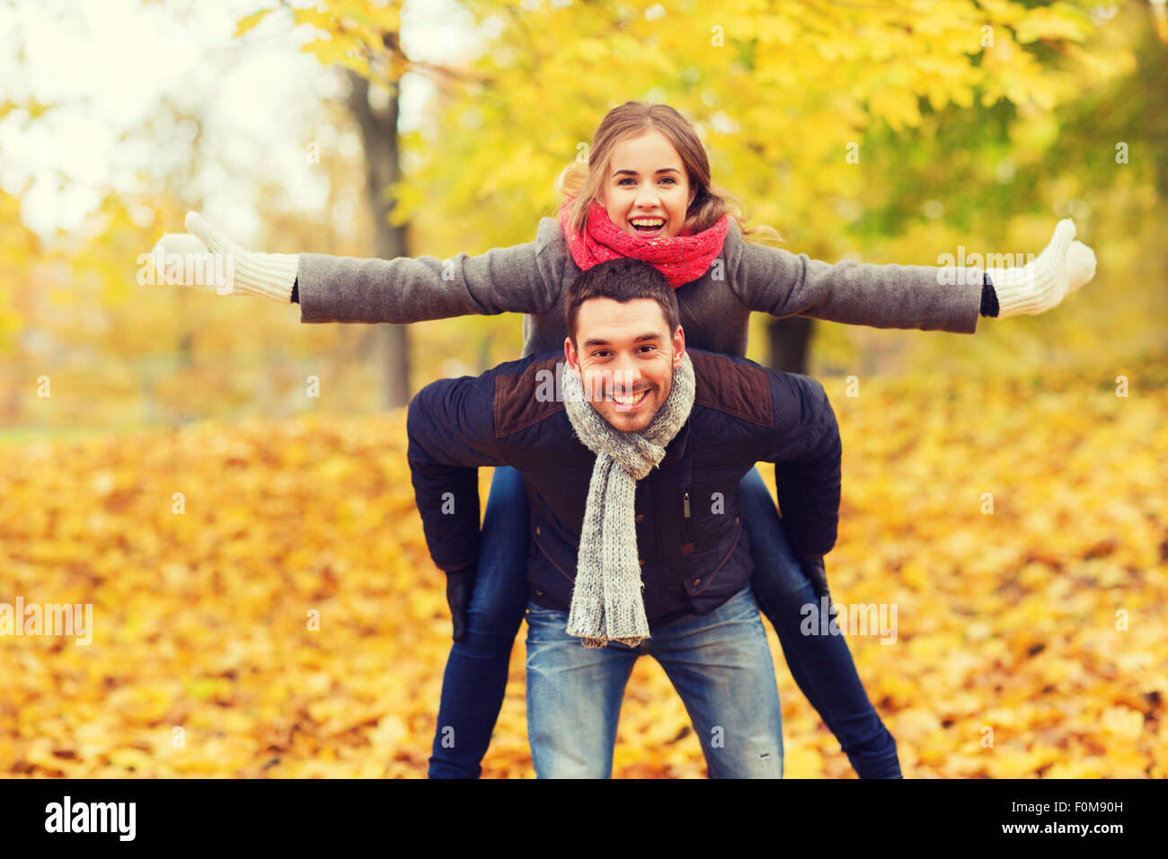 smiling couple having fun in autumn park Stock Photo - Alamy
