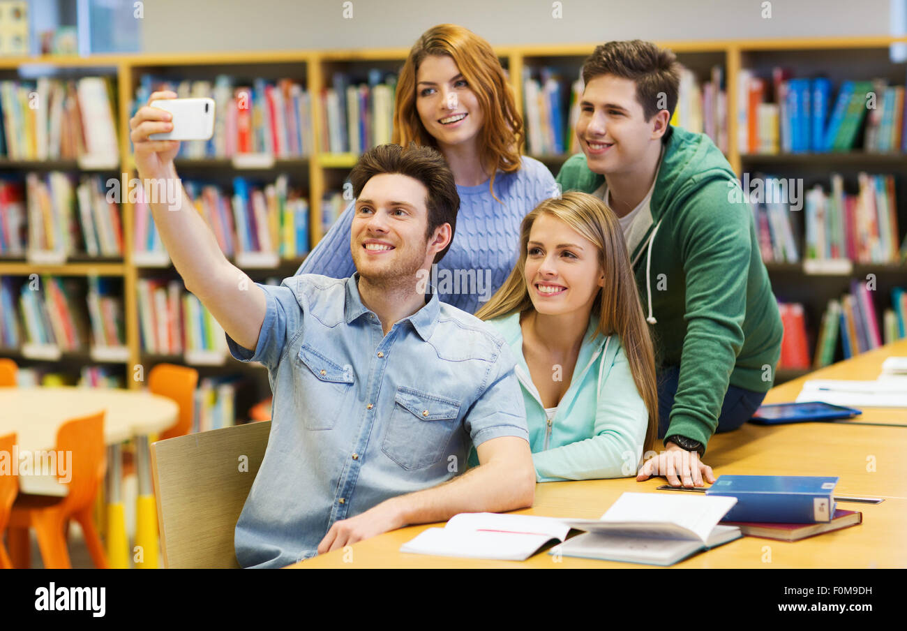 students with smartphone taking selfie in library Stock Photo - Alamy