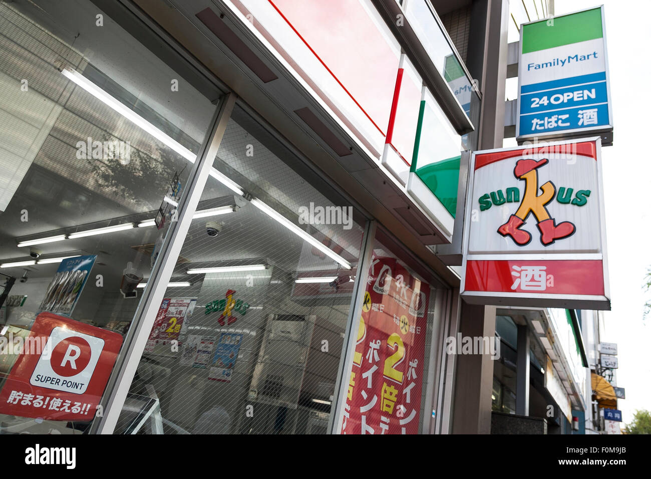 Sunkus and FamilyMart signboards on display at the entrance of their ...