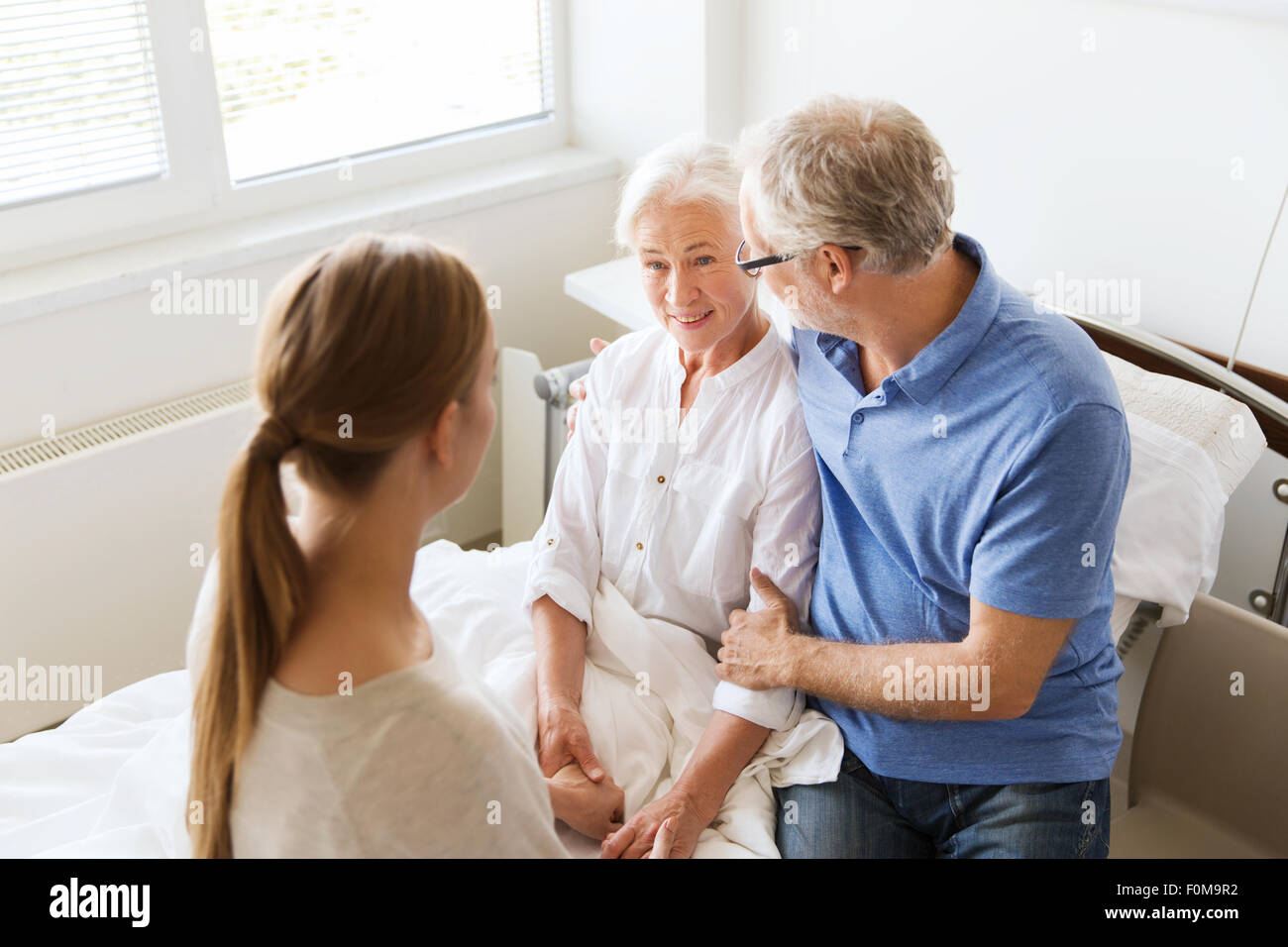 happy family visiting senior woman at hospital Stock Photo - Alamy